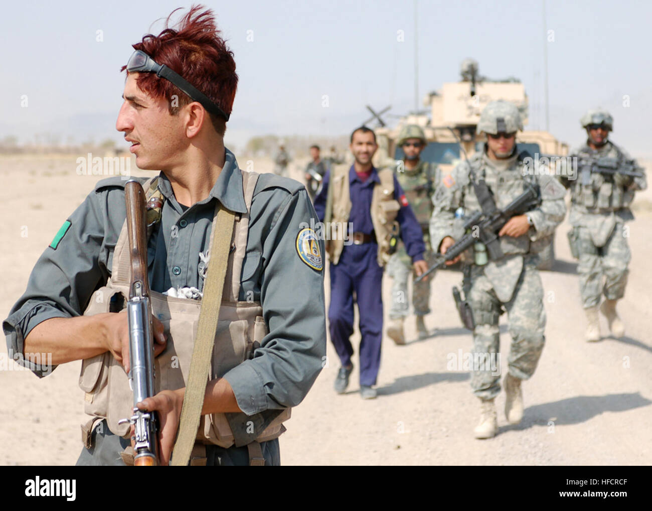 An Afghan national police officer leads Army Capt. Hunter Hill and his ...