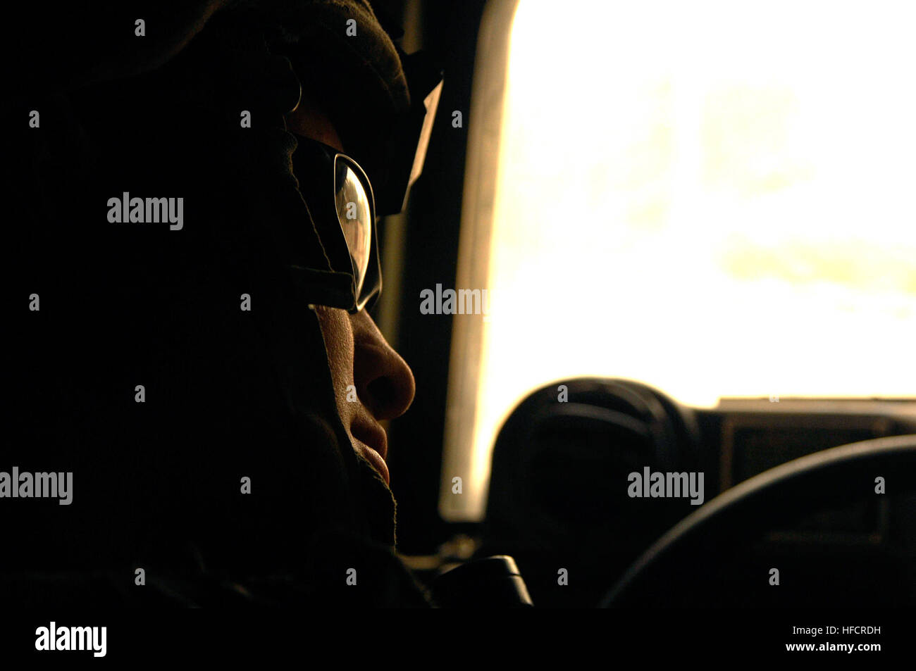 A U.S. Soldier peeks around a corner as he stands guard inside his ...