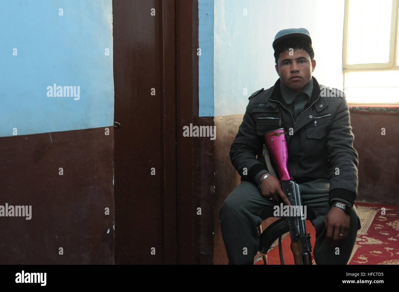 A young Afghan police officer provides security outside the Farah City ...