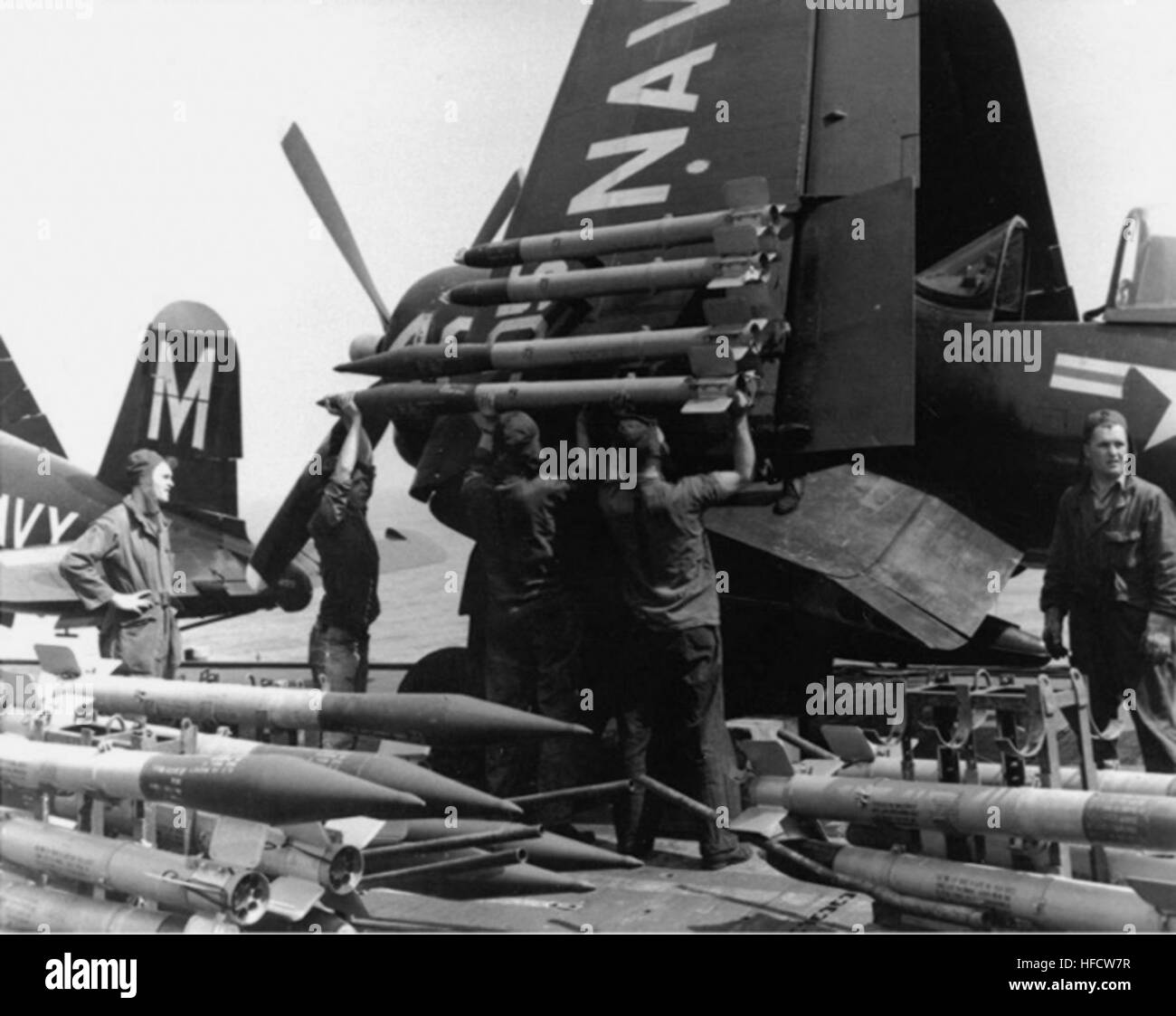 An F4U Corsair aircraft is armed with a rocket-assisted munition (HVAR ...