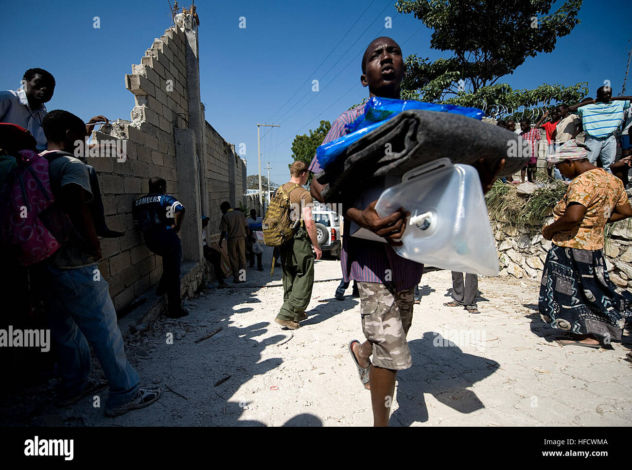 A Haitian earthquake survivor leaves a Red Cross distribution site ...