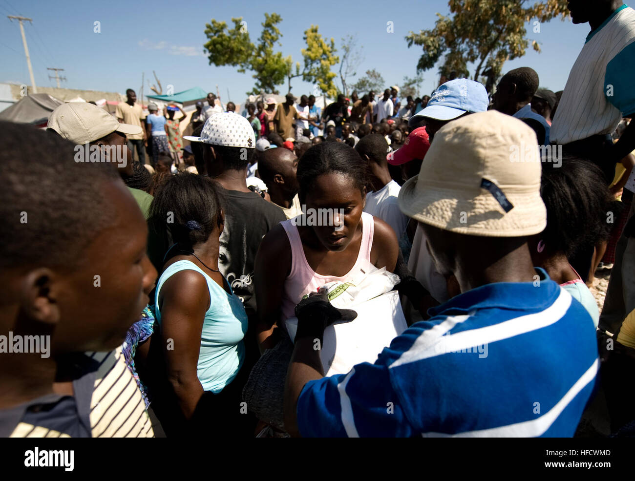 A Haitian earthquake survivor leaves a Red Cross distribution site in ...