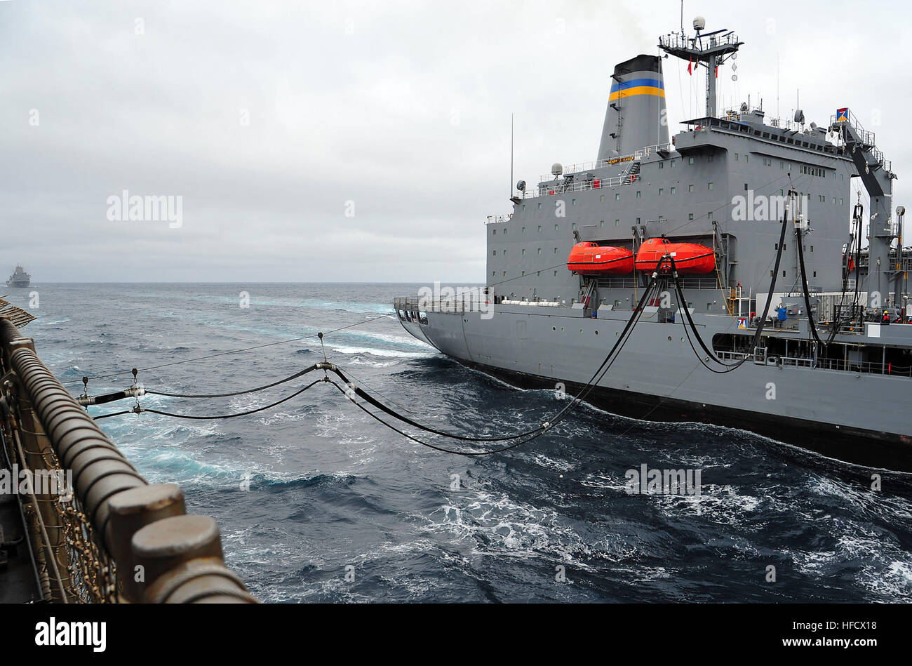 The amphibious dock landing ship USS Rushmore (LSD 47), left, conducts ...