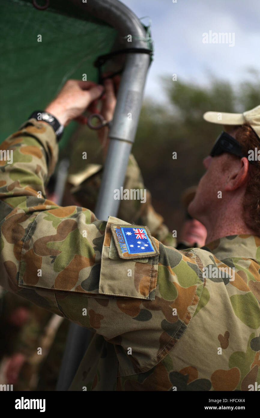 A Royal Australian Navy clearance diver helps set up a shade canopy ...