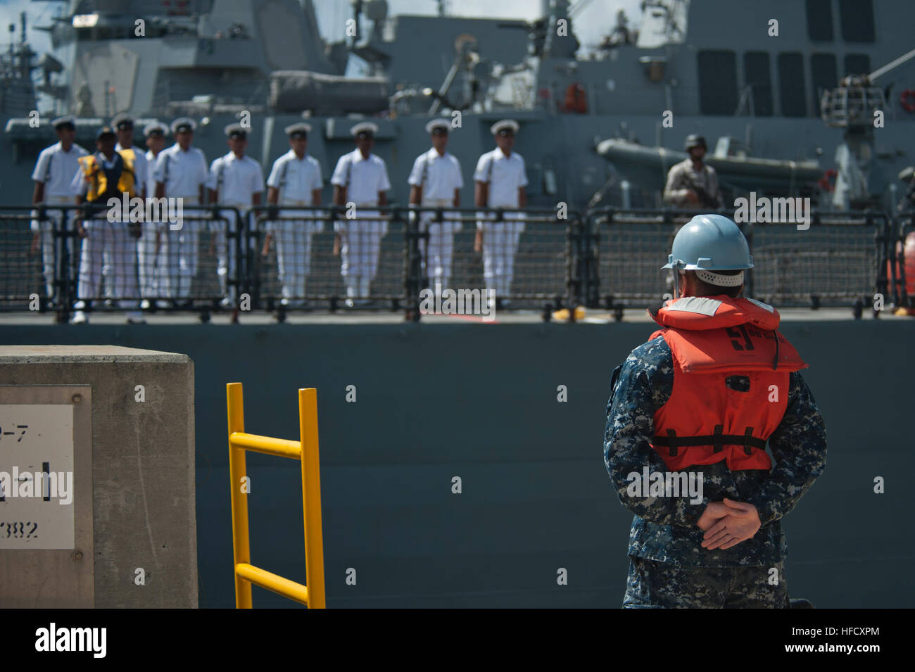 An U.S. Navy Sailor stands at parade rest while the Indian navy ...