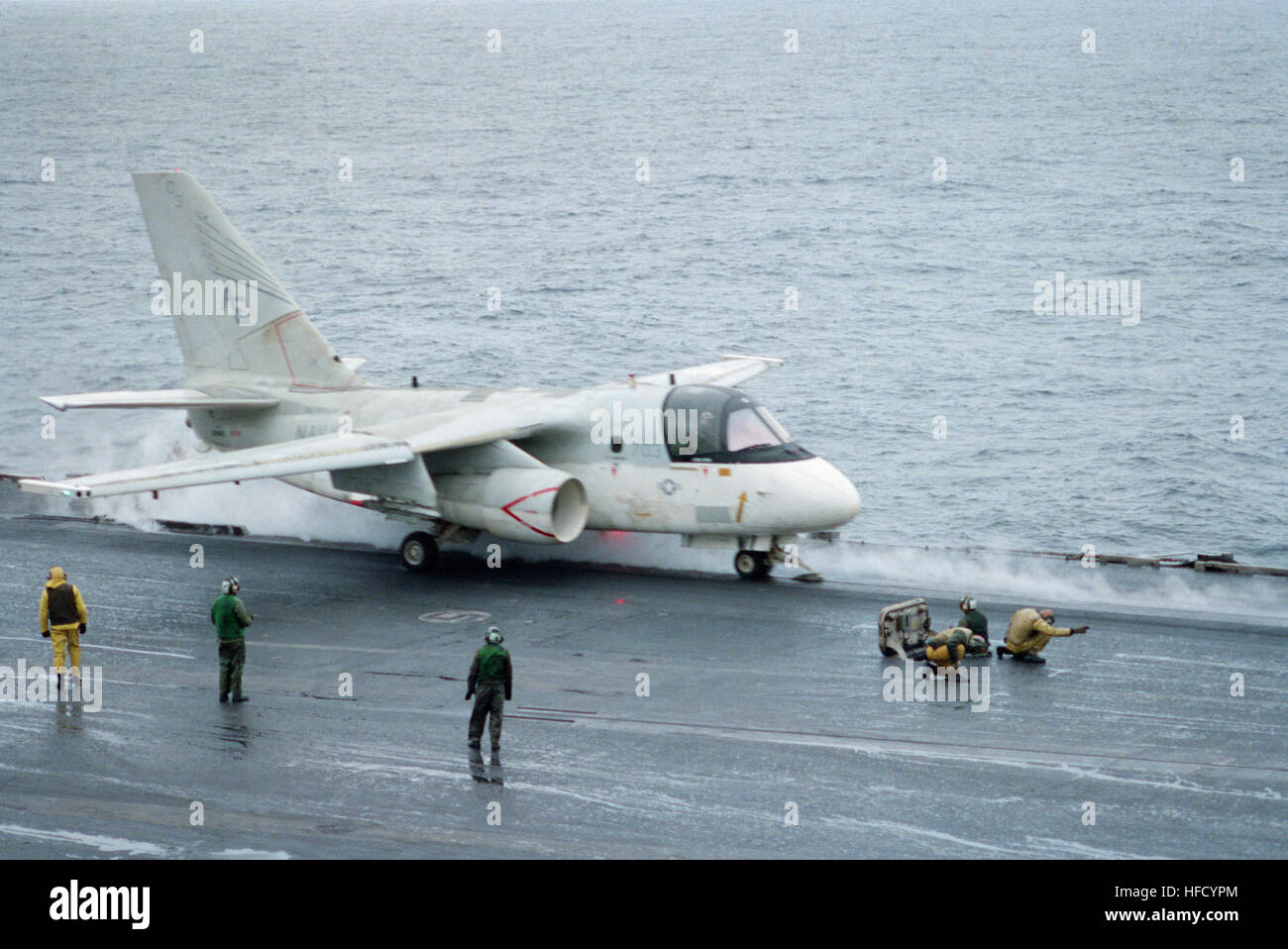 Flight deck crew members assist as an S-3A Viking aircraft is launched ...