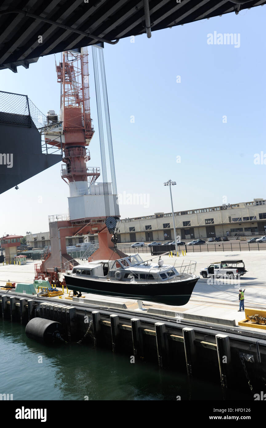 U.S. Navy Carrier Strike Group 11's admiral's barge hangs in the air as ...