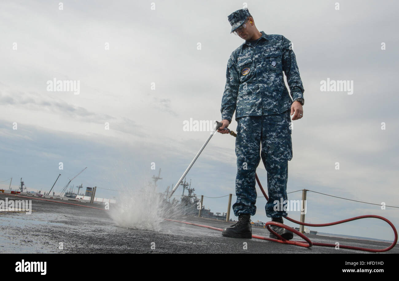 U.S. Navy Aviation Boatswain's Mate Airman Anthony Whitley clears rain ...