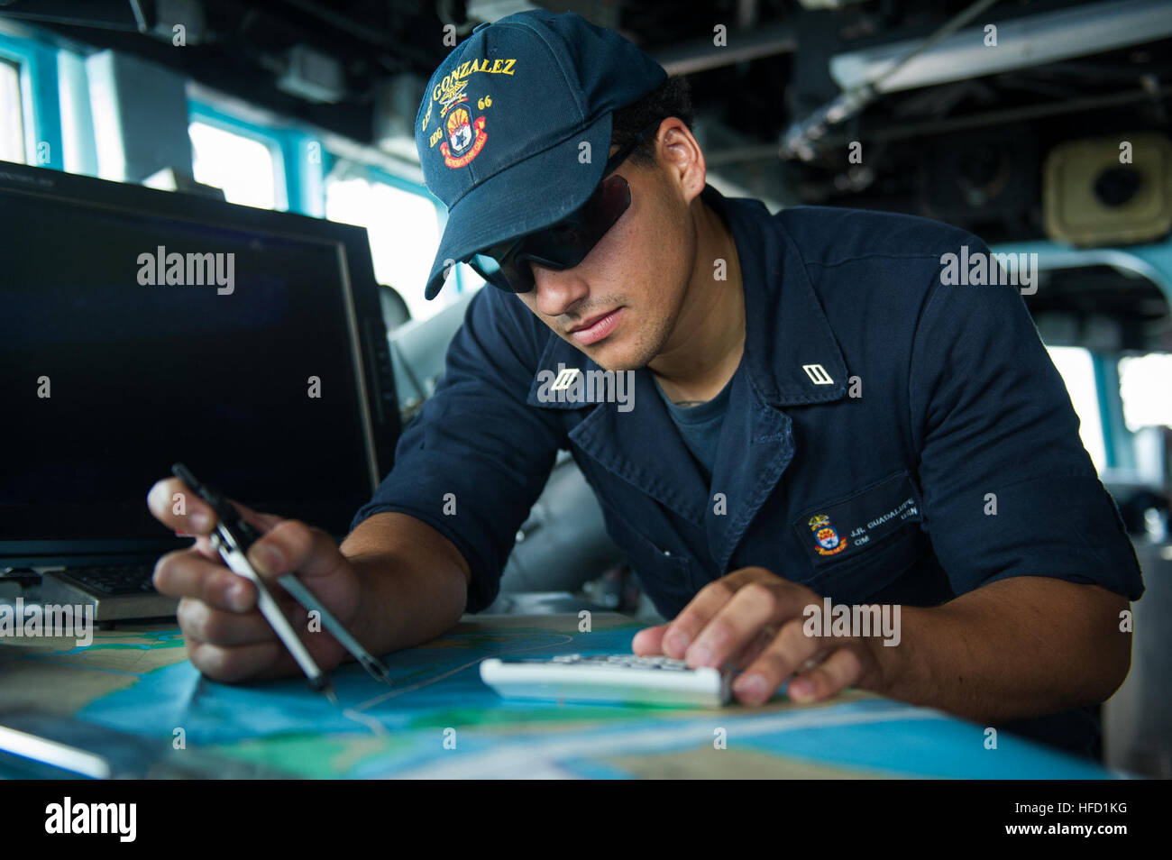 Quartermaster Seaman plots a course in the pilothouse aboard USS ...