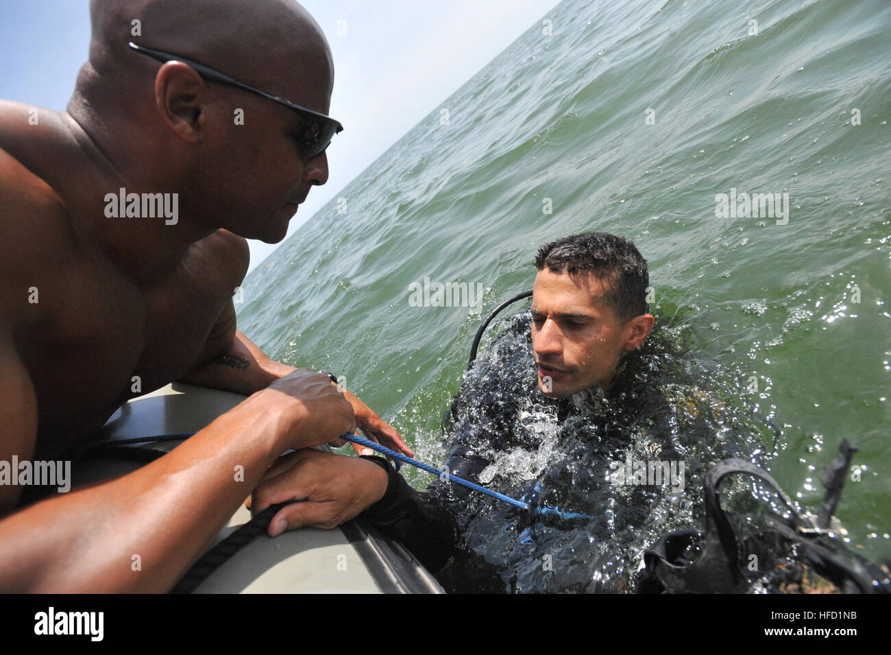 A U.S. Navy line tender supports a diver from Explosive Ordnance ...