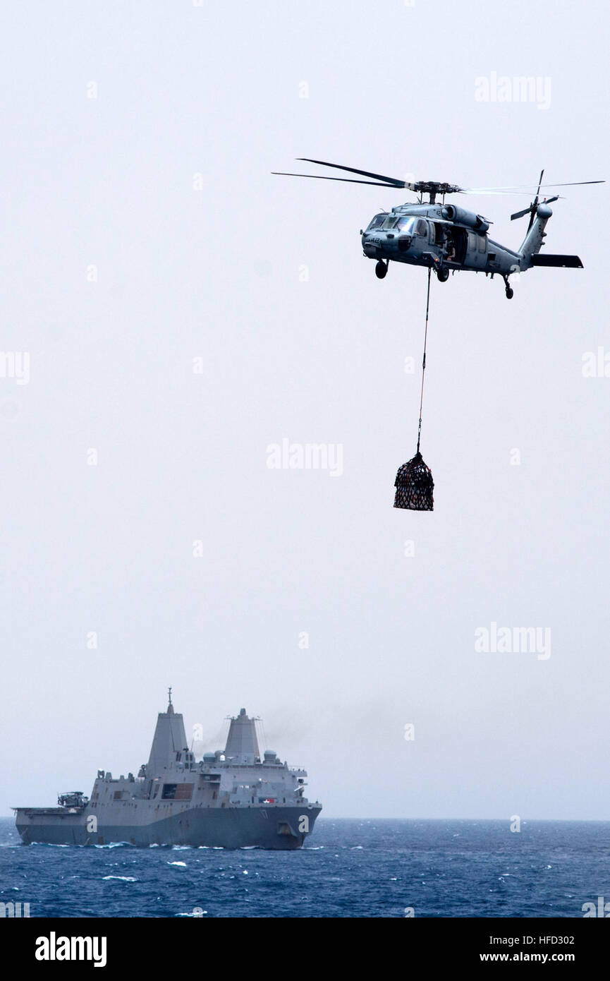 An MH-60 Seahawk helicopter transports cargo to the amphibious dock ...