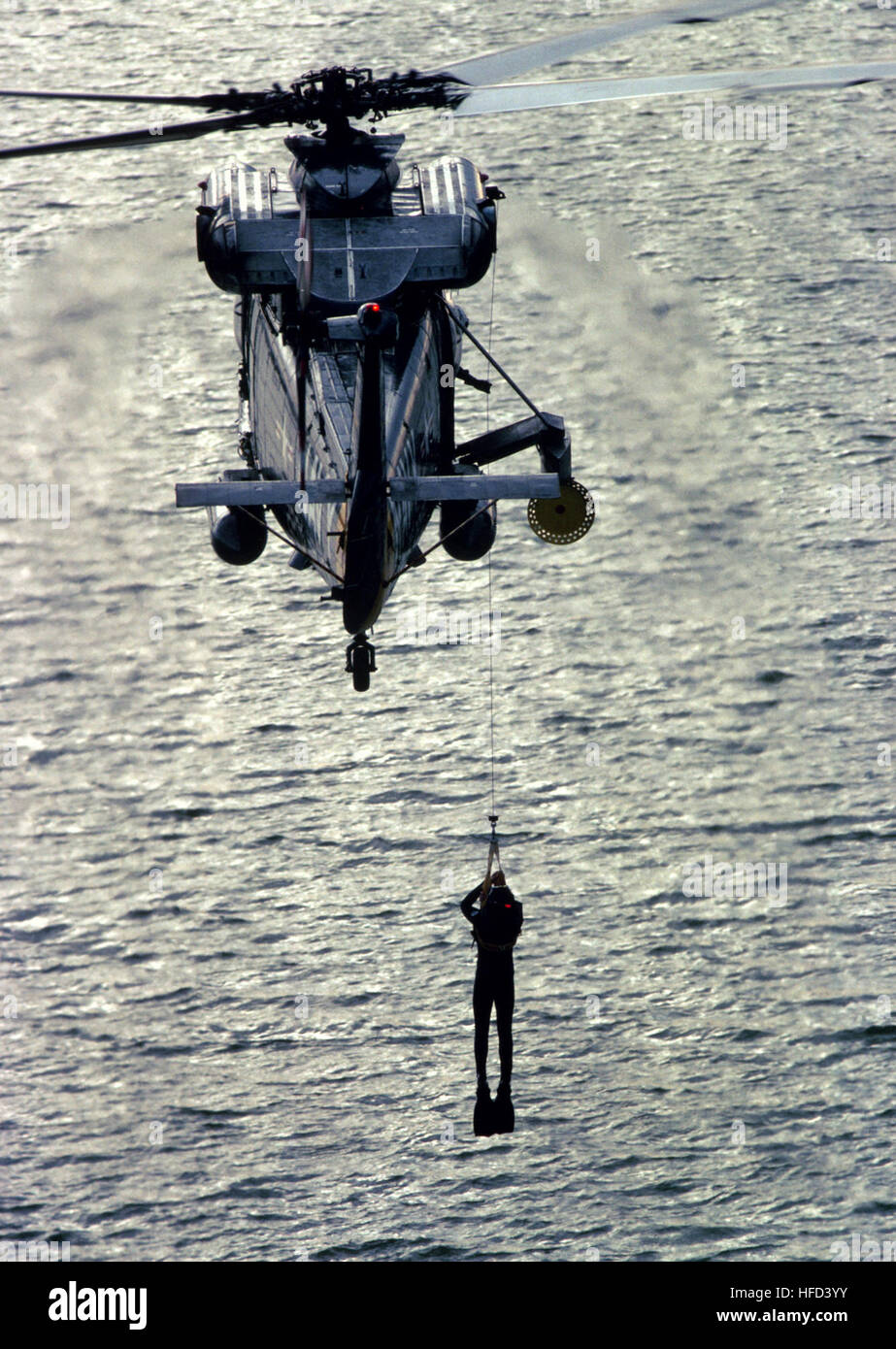 A search and rescue swimmer is hoisted aboard a Helicopter Light Anti ...
