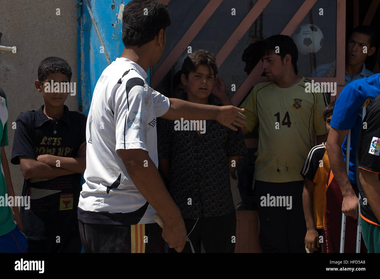 An Iraqi boy plays with his friends as U.S. Soldiers pass by in the ...