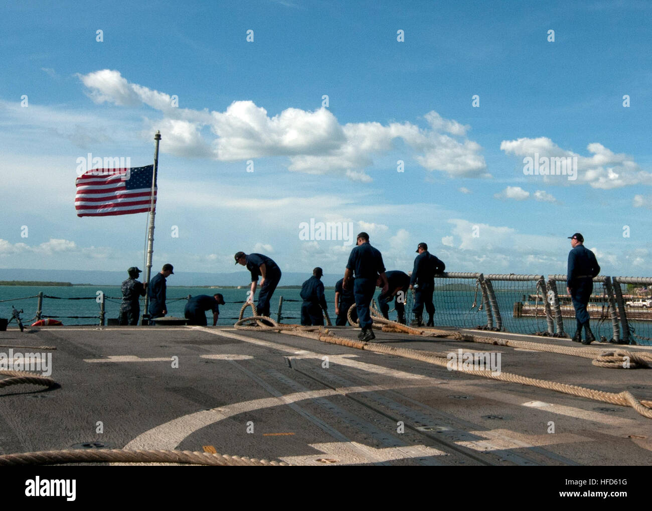 U.S. sailors handle mooring lines on the flight deck as guided missile ...