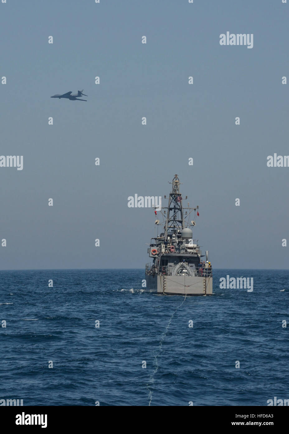 A U.S. Air Force B-1B bomber flies over the coastal patrol ship USS ...