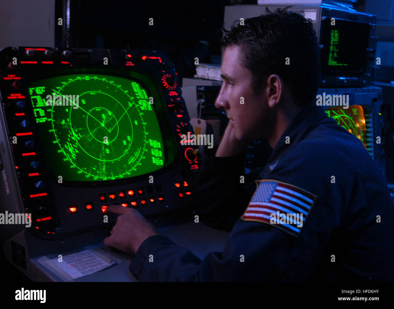 An Operational Specialist scans for surface contacts on the SPS-67 ...