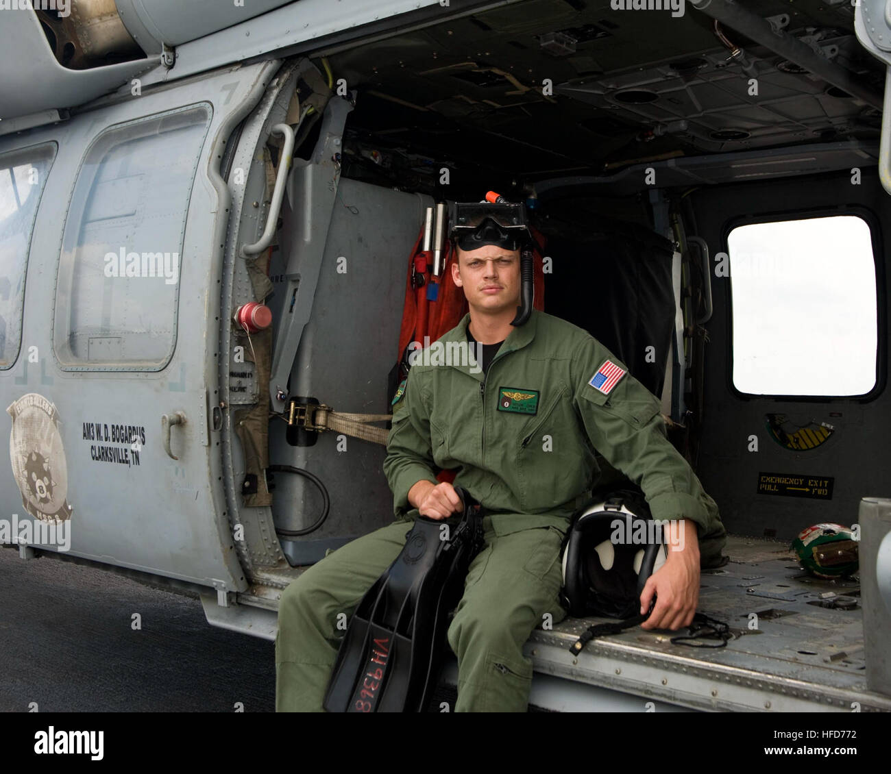 Naval Aircrewman (Helicopter) 3rd Class Tyler Child sits in an MH-60S ...