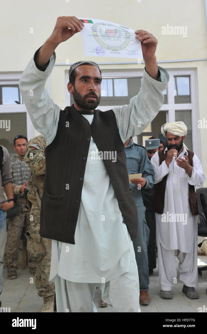 An Afghan Local Police graduate proudly holds up his certificate up ...