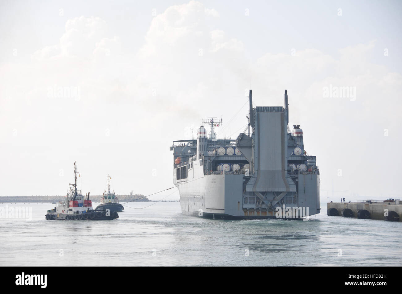 Tugboats guide the container ship MV Cape Ray (T-AKR 9679) away from a ...