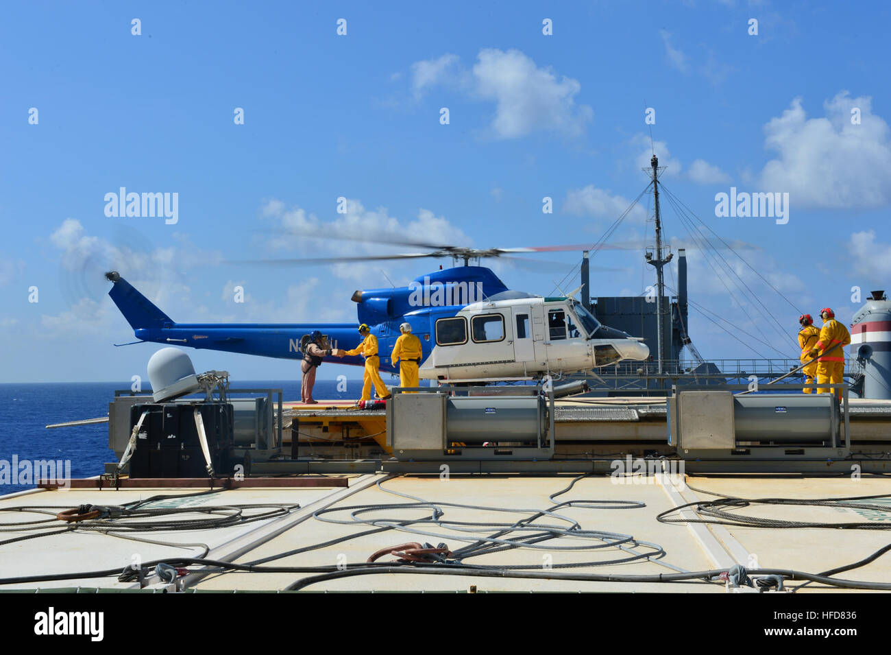 Crew aboard MV Cape Ray unload cargo from a helicopter in the ...