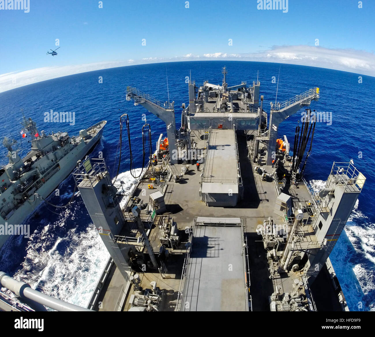 The dry cargo and ammunition ship USNS Cesar Chavez (T-AKE 14), right ...