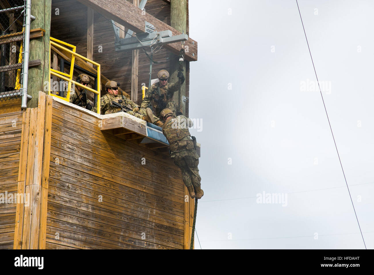 Explosive Ordnance Disposal Technicians fast rope from a tower during a ...