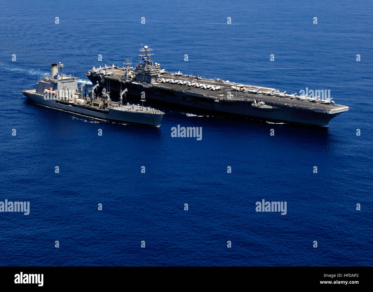 The Military Sealift Command fleet replenishment oiler USNS John Lenthall steams alongside the ...