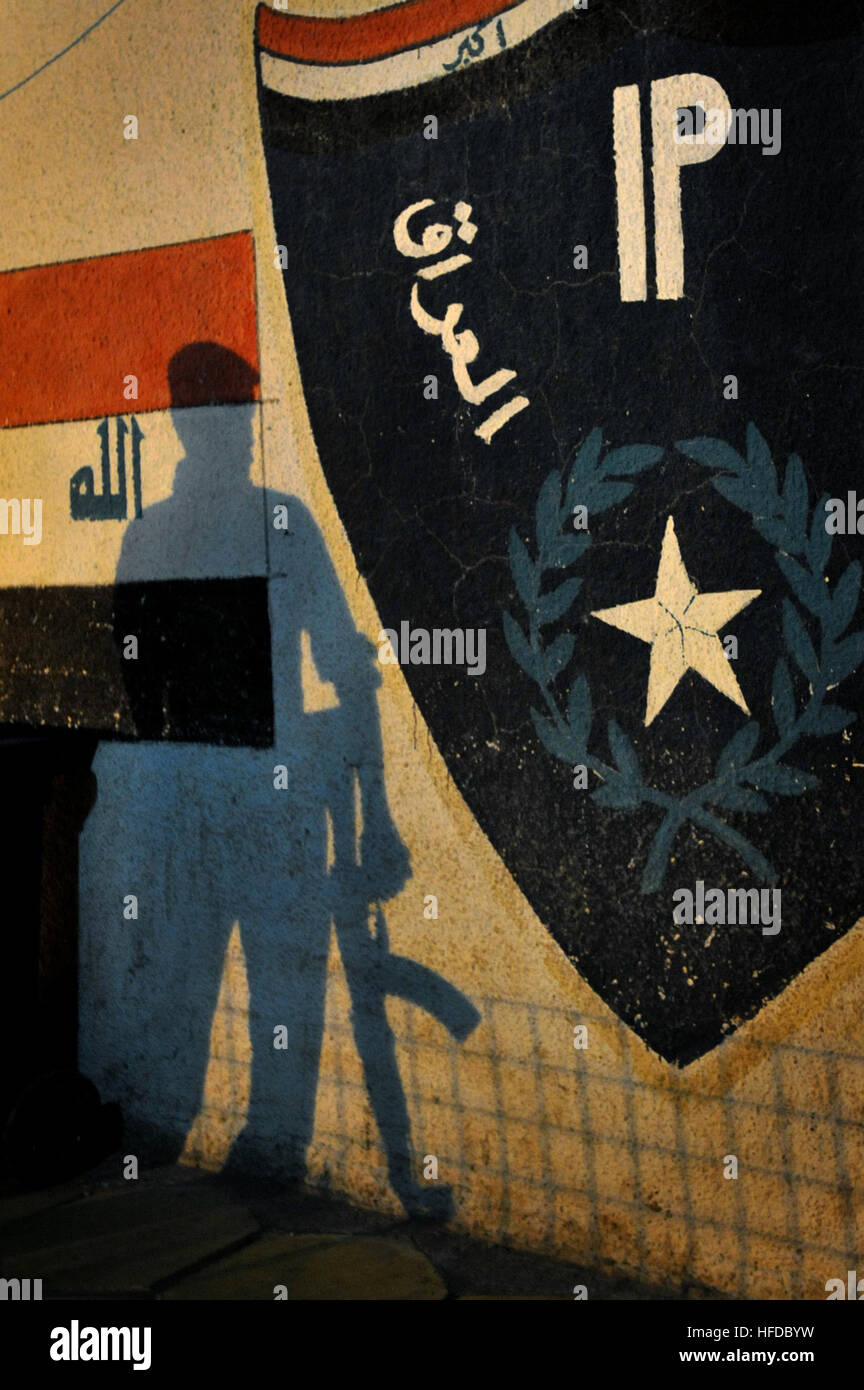 An Iraqi police officer casts his shadow on the IP crest outside the ...