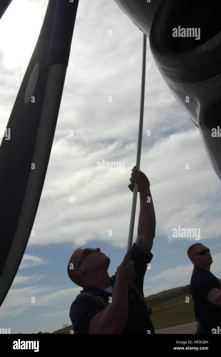 Navy Petty Officer 3rd Class Kenneth Ellul scrubs the wing of a C-2 ...
