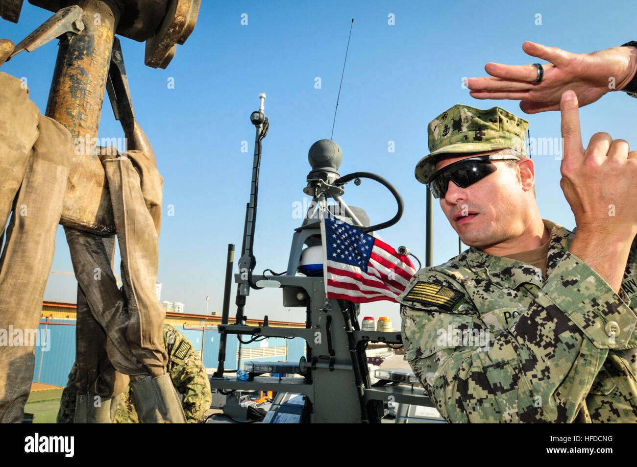 U.S. Navy Chief Engineman Sam Pona signals hoisting strap positions to ...