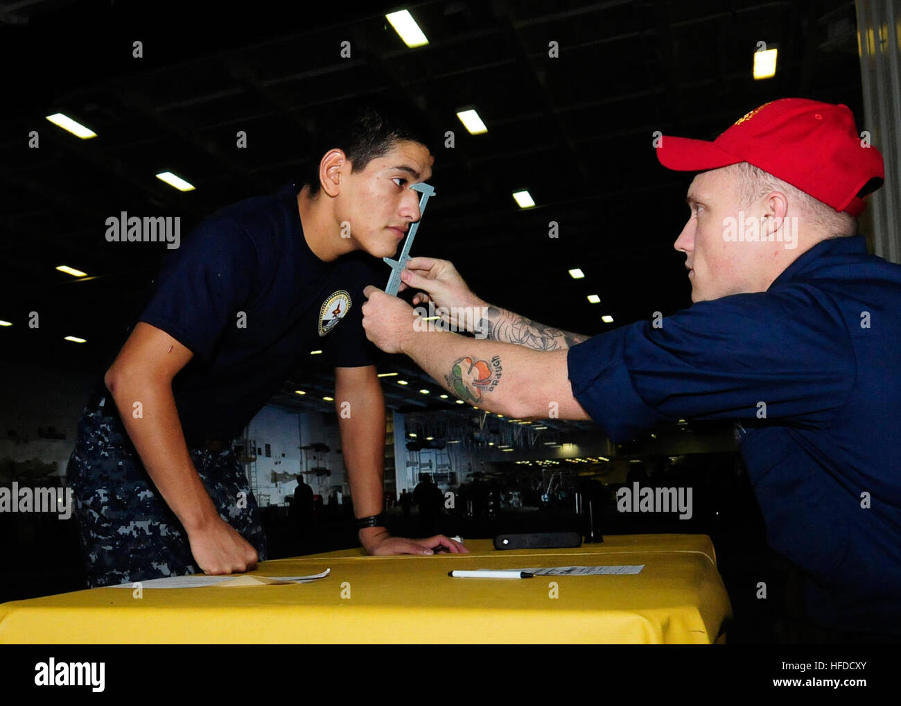 U.S. Navy Damage Controlman 3rd Class Alex C. McNight, right, assigned ...