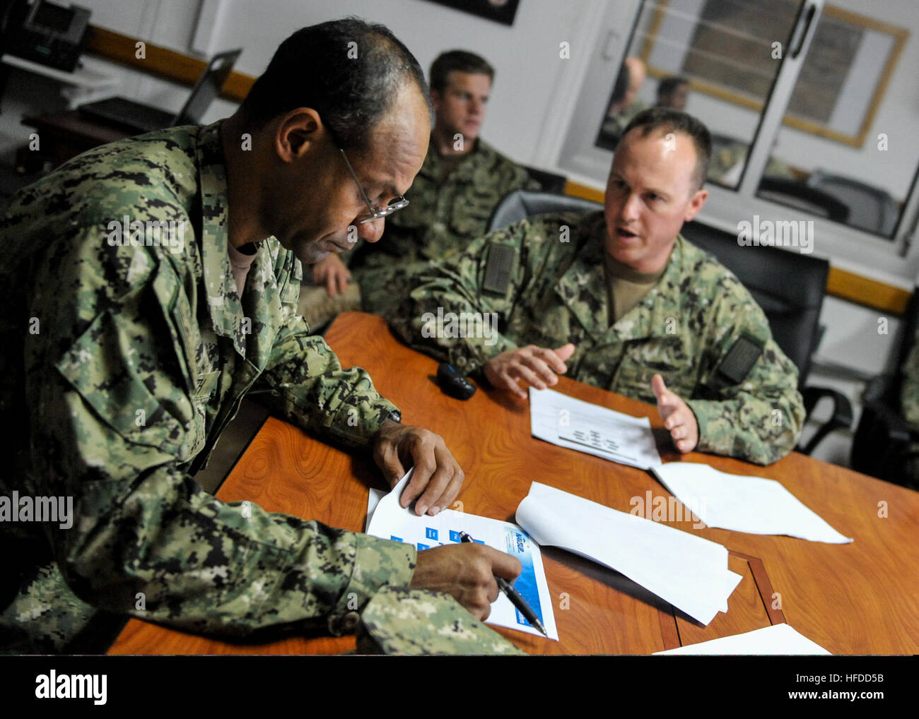 U.S. Navy Lt. Cmdr. Kelly House, right, a supply officer, briefs Rear ...