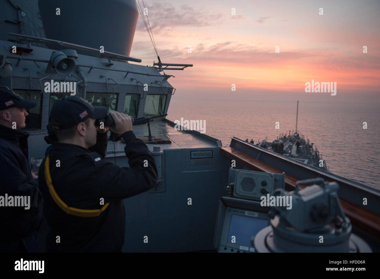 U.S. Navy Lt.j.g. Samuel Braddock, right, looks through binoculars for ...