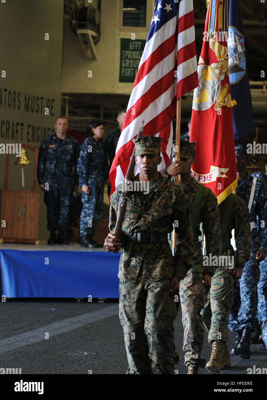 U.S. Sailors and Marines assigned to the color guard parade the colors ...