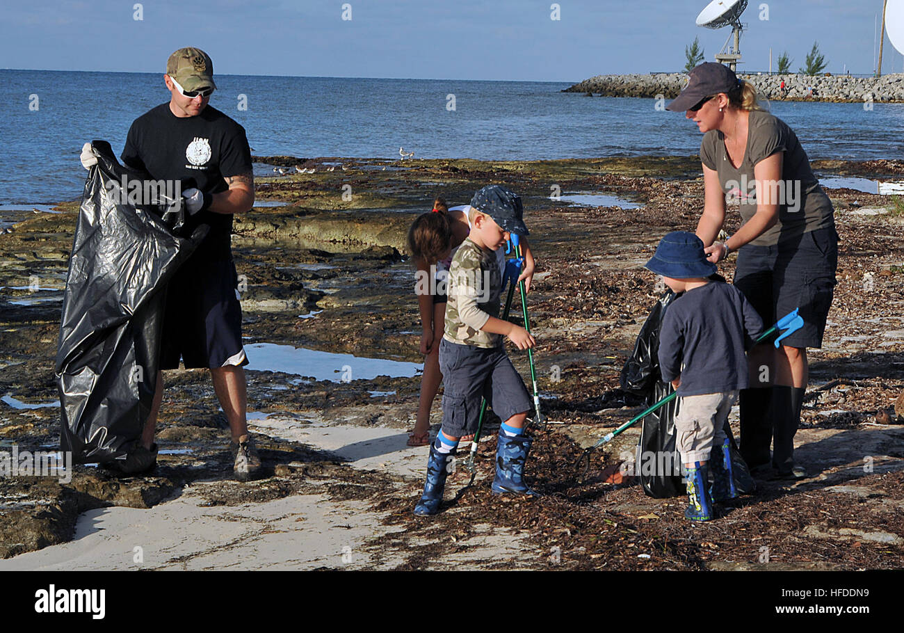 U.S. Sailors and members of their families help clean up litter at ...
