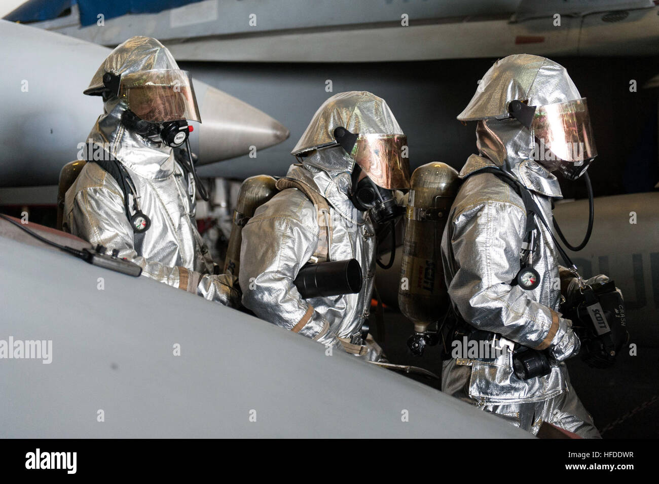 U.S. Sailors dressed in proximity suits simulate a hot spot search with ...