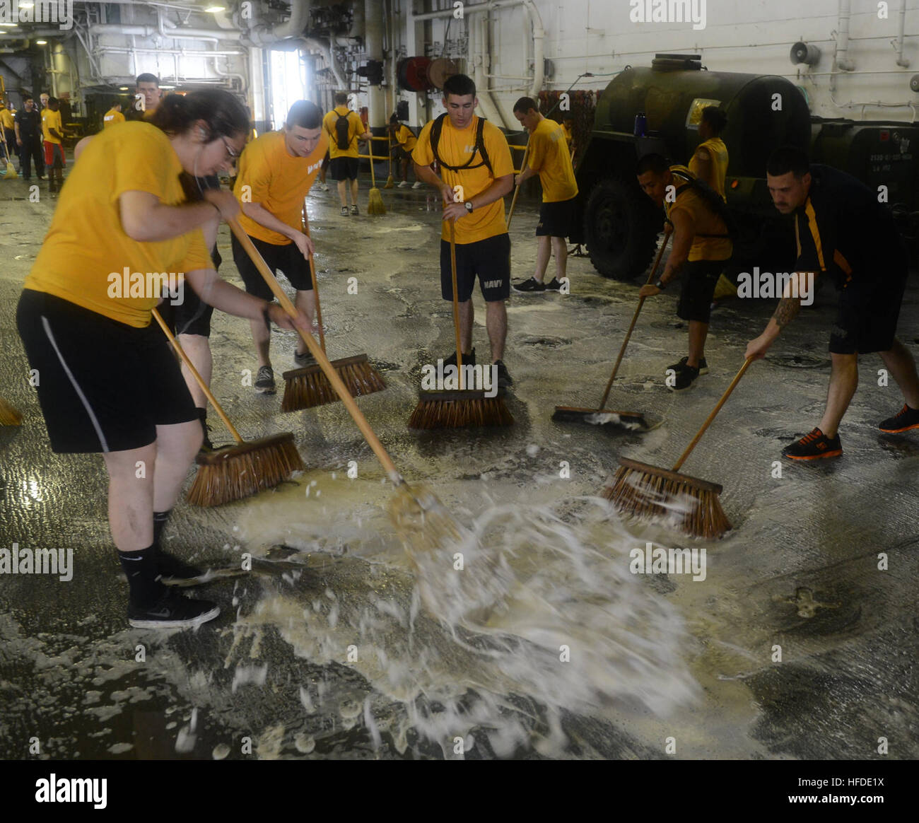 U.S. Sailors scrub the deck aboard the amphibious assault ship USS ...