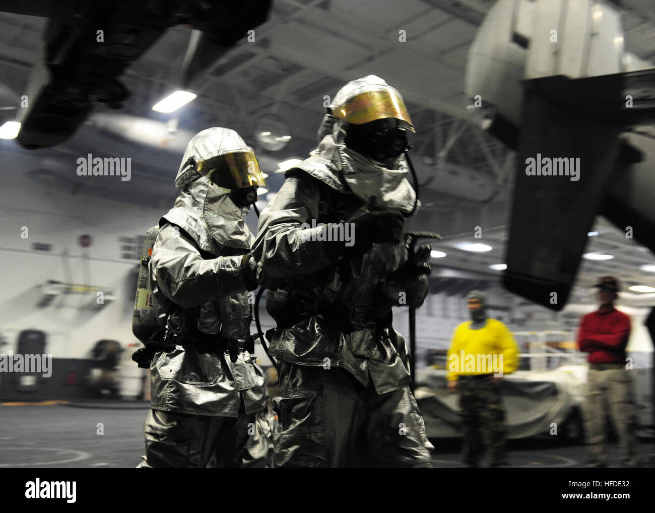 U.S. Sailors wearing hot suits, or firefighting ensemble, inspect a ...