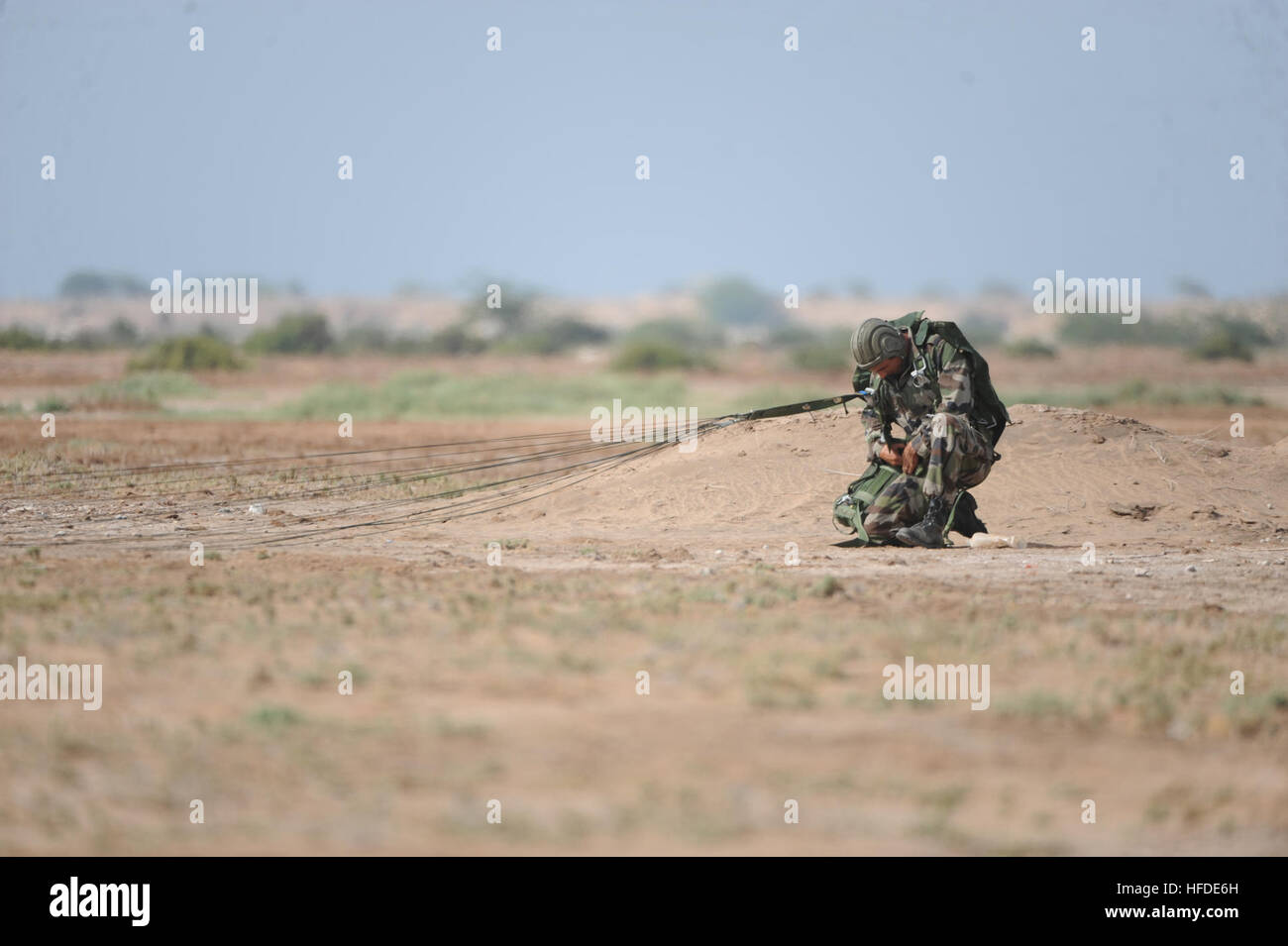 A French commando removes his parachute harness after landing in the ...
