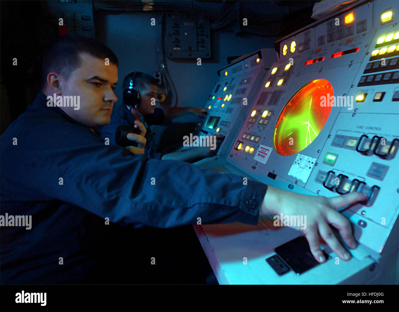 Fire control personnel operate the firing officer console aboard the ...