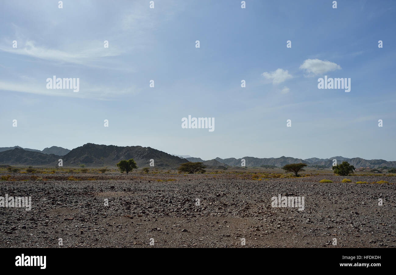 Mountains in gravel desert with blue sky, Oman Stock Photo - Alamy