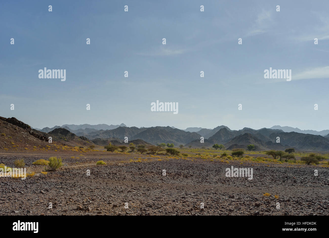 Mountains in gravel desert with blue sky, Oman Stock Photo - Alamy