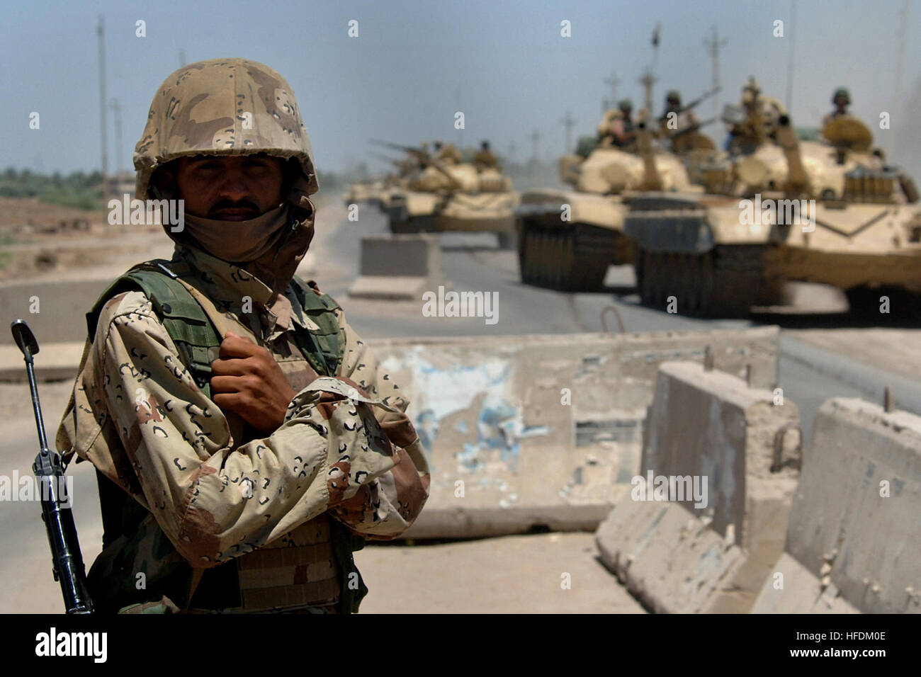 An Iraqi army soldier stands guard duty while Iraqi army soldiers from ...