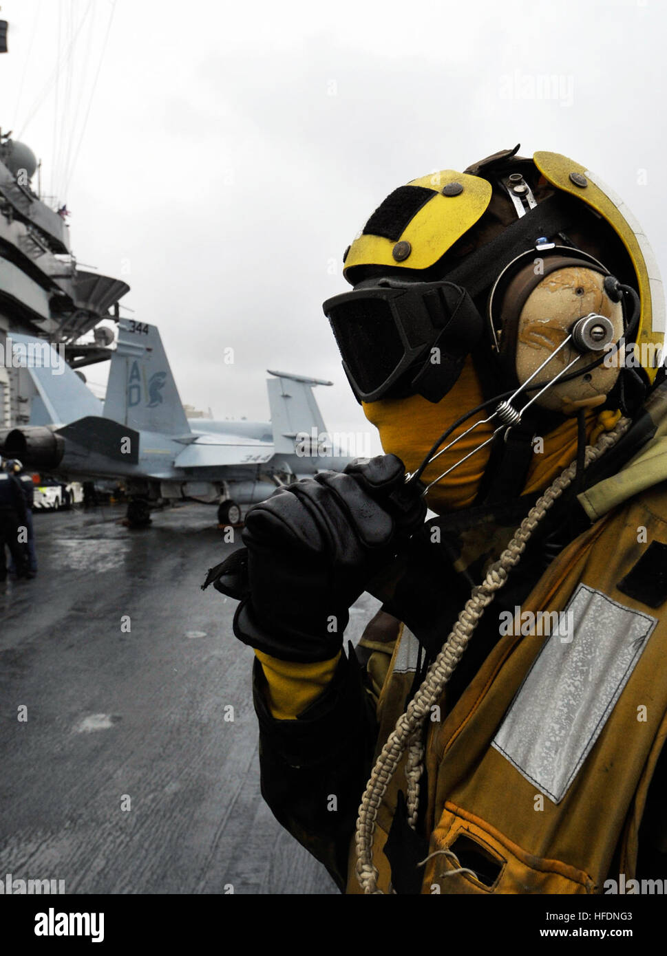A U.S. Navy aircraft director communicates with flight deck control on ...