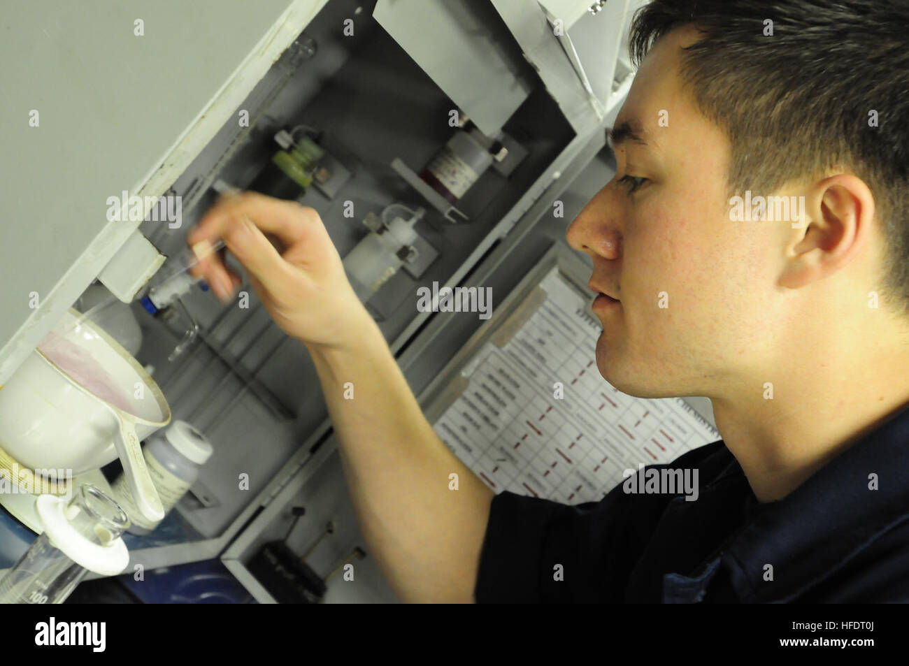 Machinist Mate Fireman Apprentice Christopher Aho stirs a feed water ...