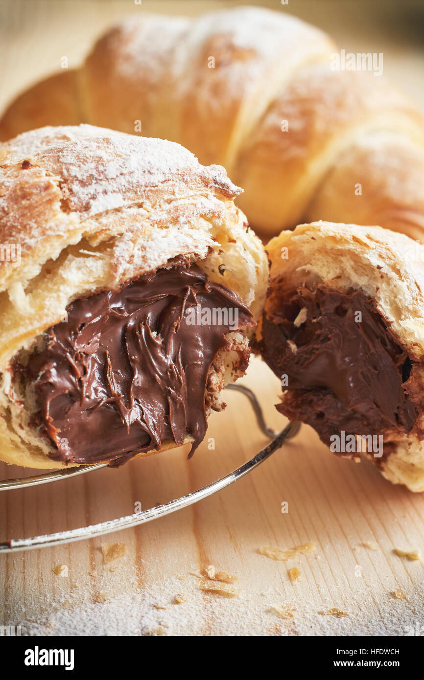 Closeup of croissant with chocolate filling on wooden background Stock ...