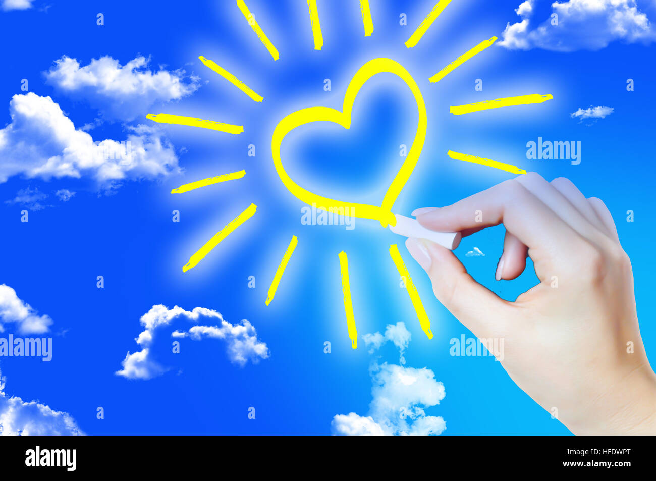 Hand painting a heart shape sun on sky Stock Photo - Alamy