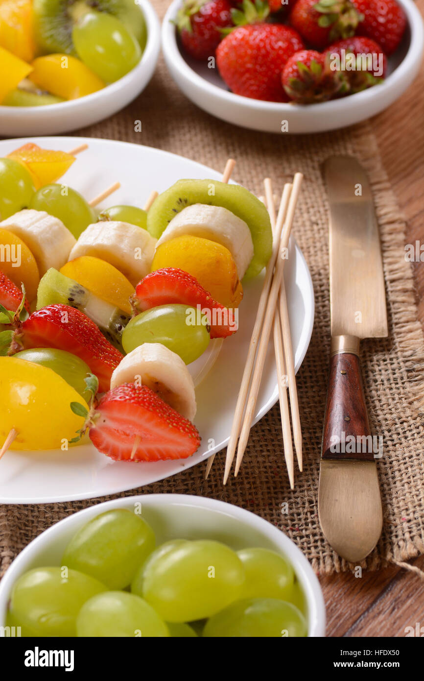 assorted fruit skewers with grapes, kiwi, banana, strawberry and plum ...