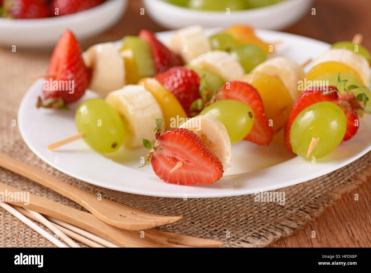 assorted fruit skewers with grapes, kiwi, banana, strawberry and plum ...