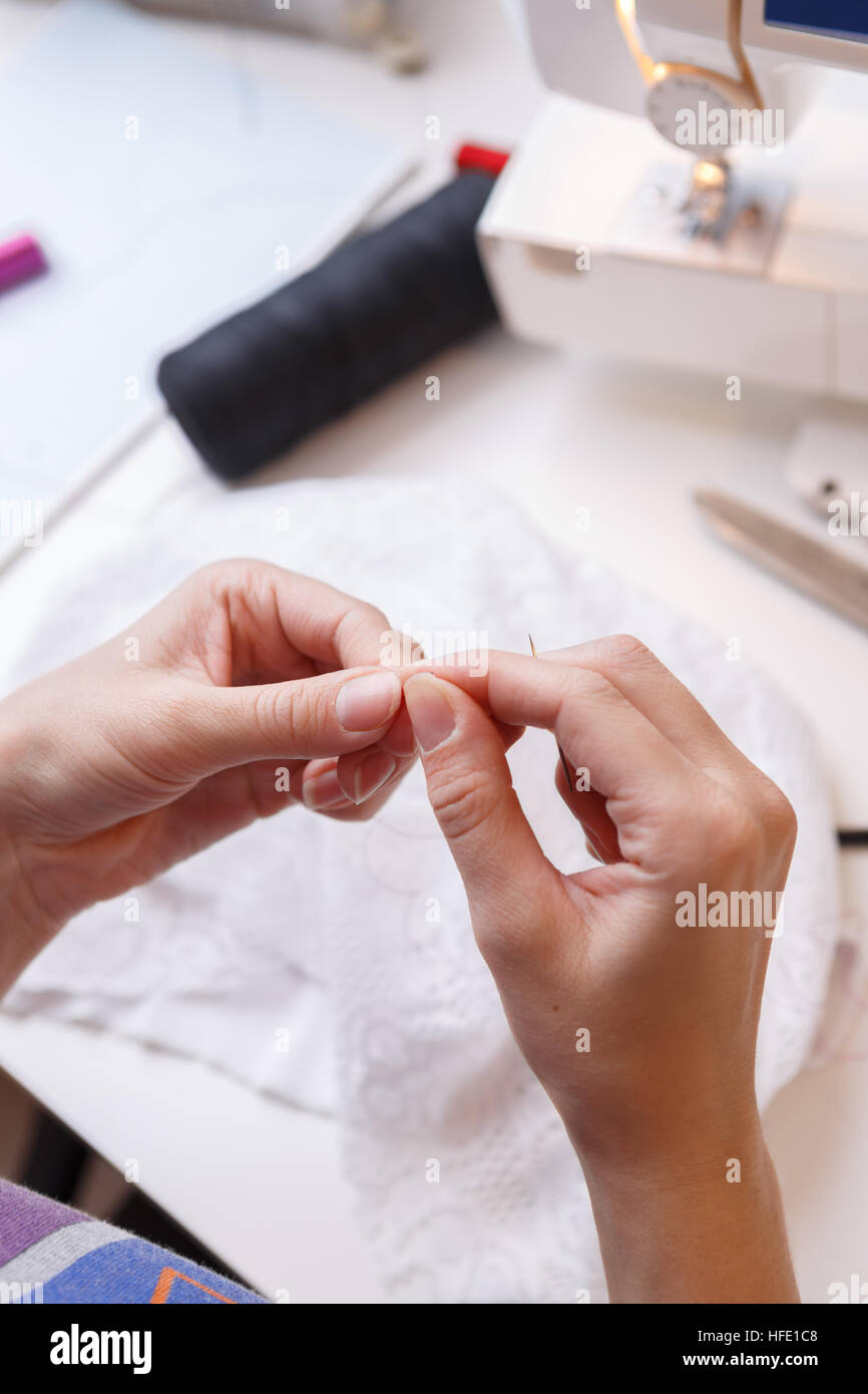 Dressmaker cuts thread in fabric Stock Photo - Alamy
